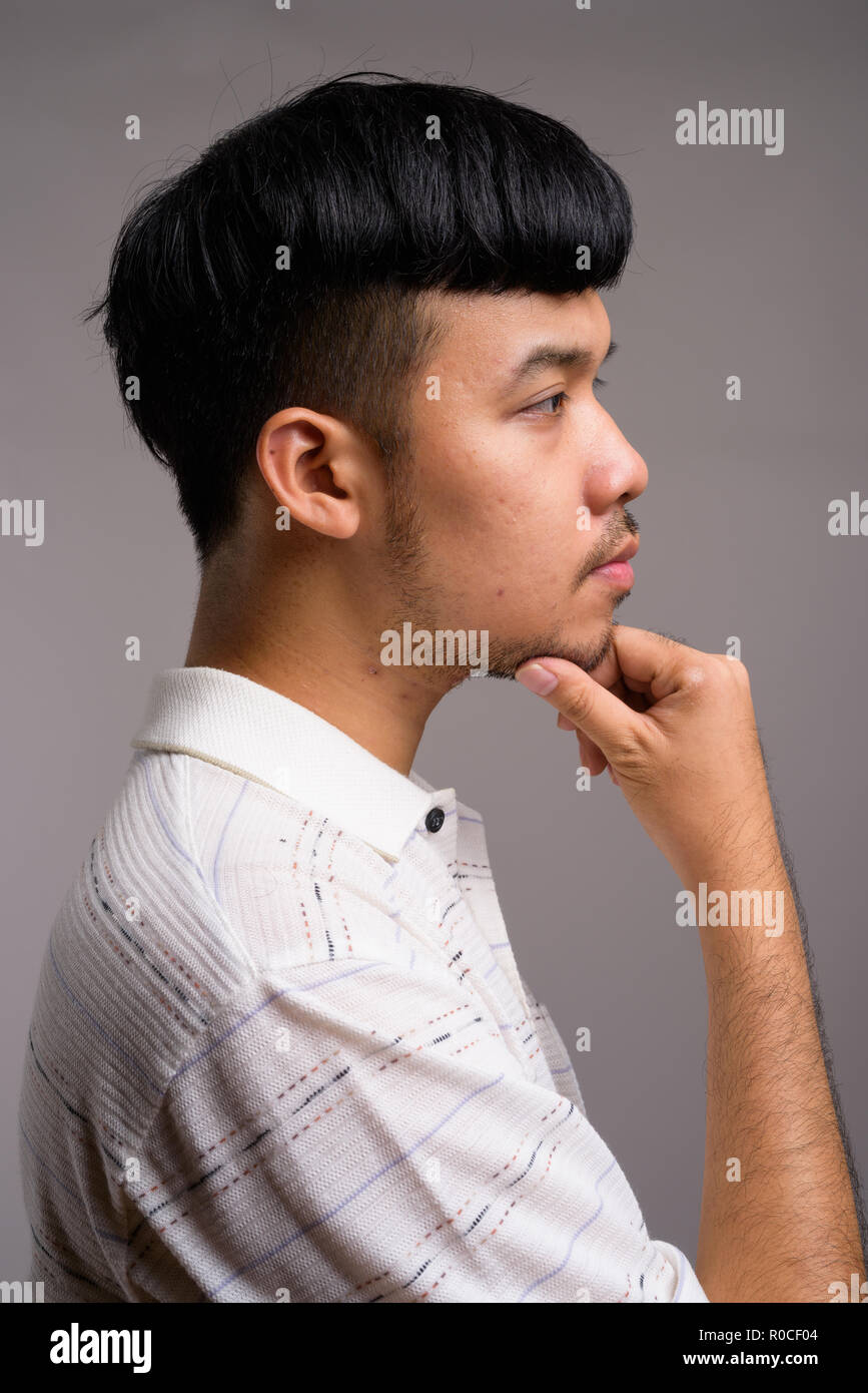 Profile view of young Asian man thinking Stock Photo - Alamy