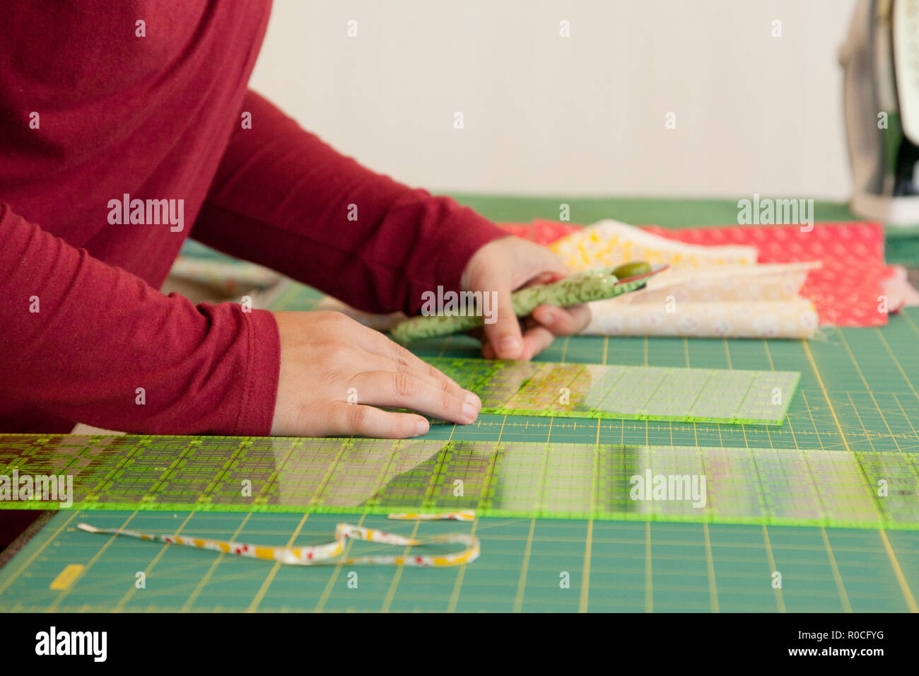 Plastic measuring grid and fabric roll cutter show a person preparing ...