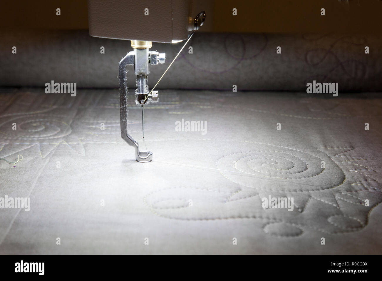 Grey blanket with sewing machine and thread making swirl pattern Stock ...