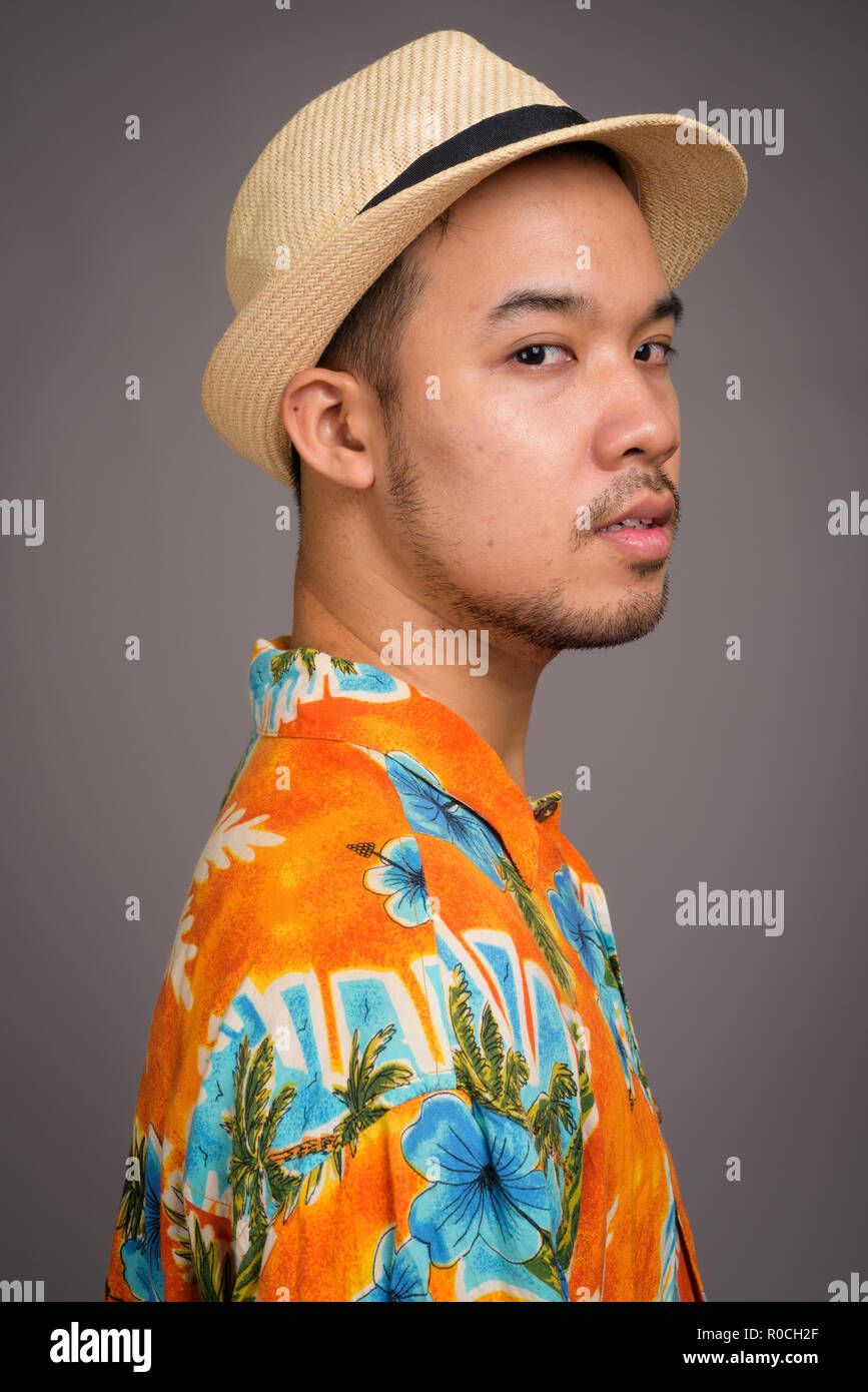 Young Asian tourist man ready for vacation against gray backgrou Stock ...