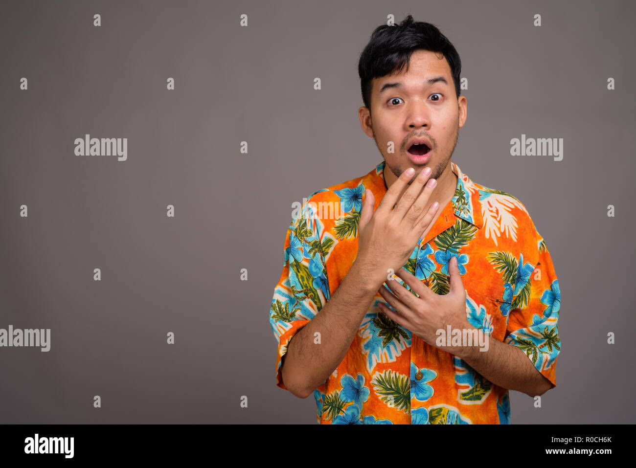 Young Asian tourist man ready for vacation against gray backgrou Stock ...