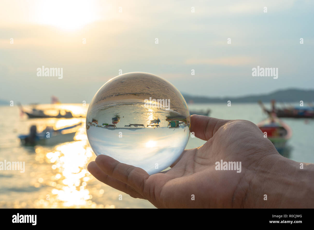 crystal glass ball sphere reveals sunrise seascape with spherical ...
