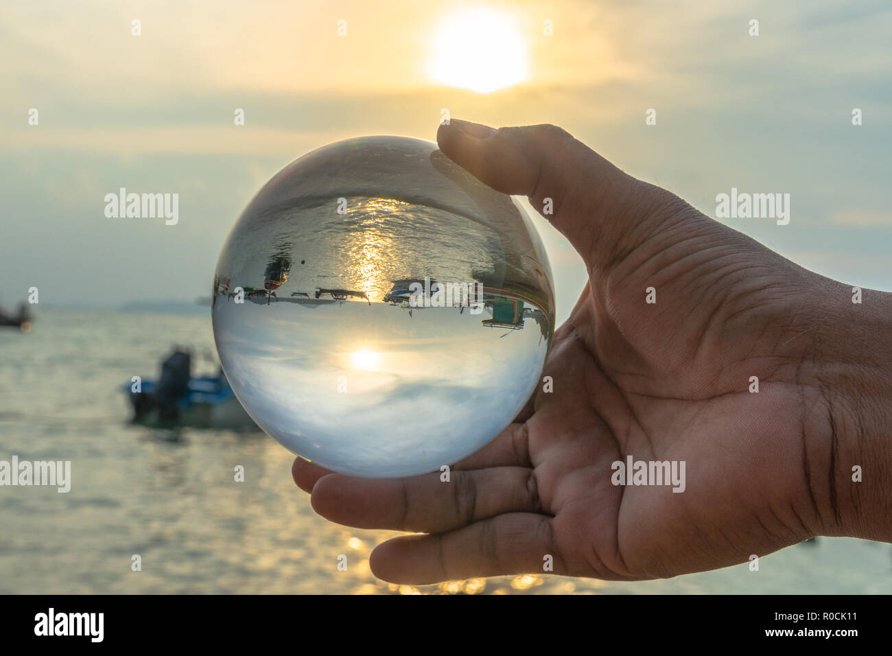 crystal glass ball sphere reveals sunrise seascape with spherical ...
