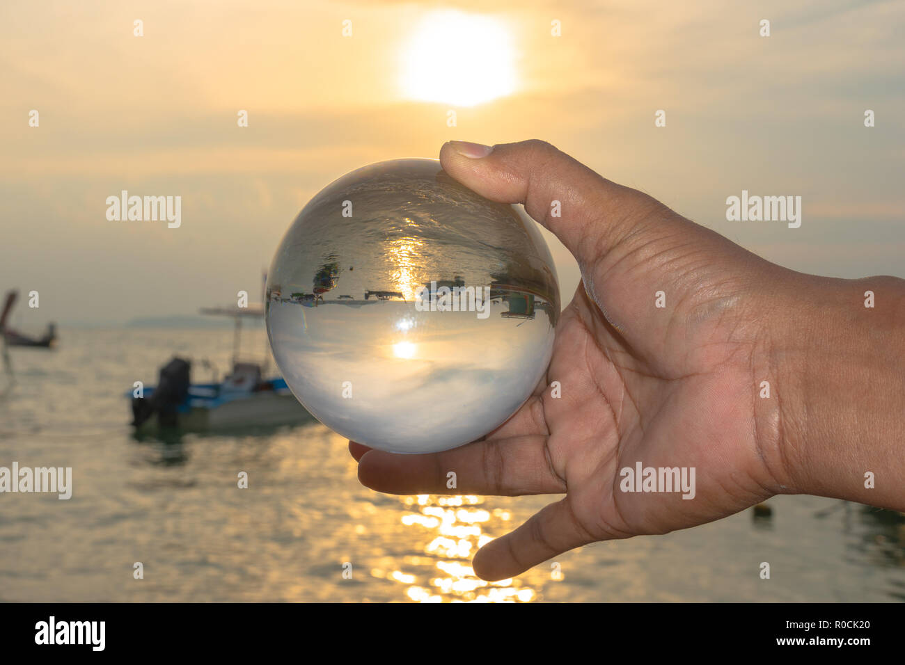 crystal glass ball sphere reveals sunrise seascape with spherical ...