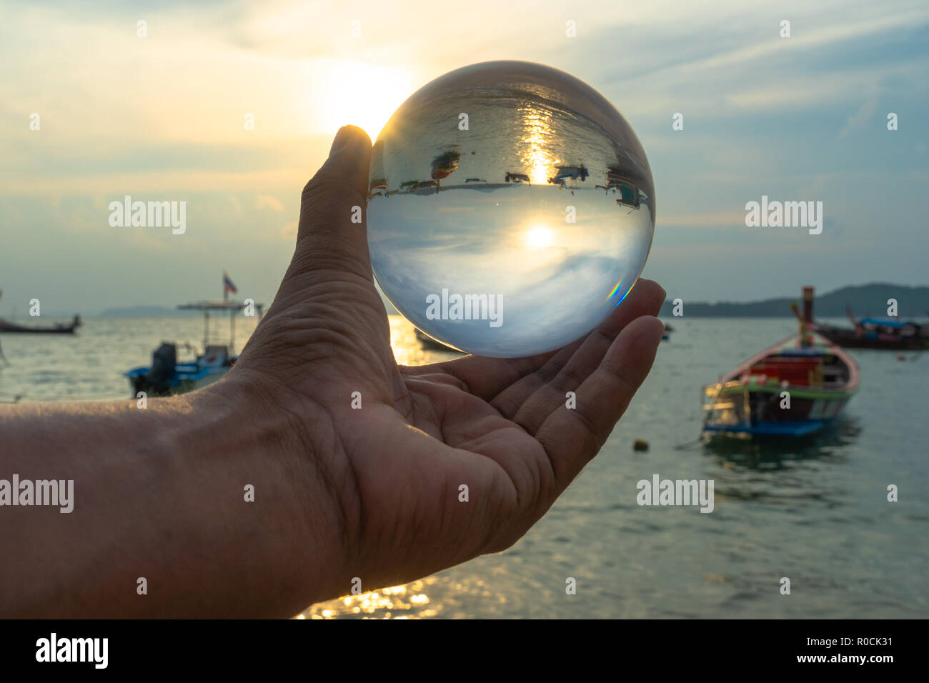crystal glass ball sphere reveals sunrise seascape with spherical ...