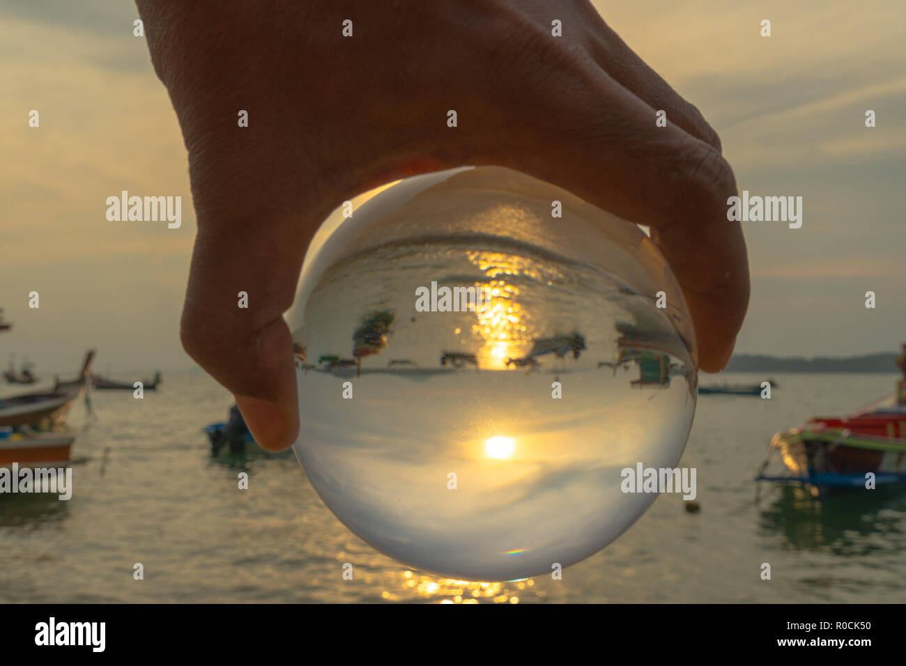crystal glass ball sphere reveals sunrise seascape with spherical ...