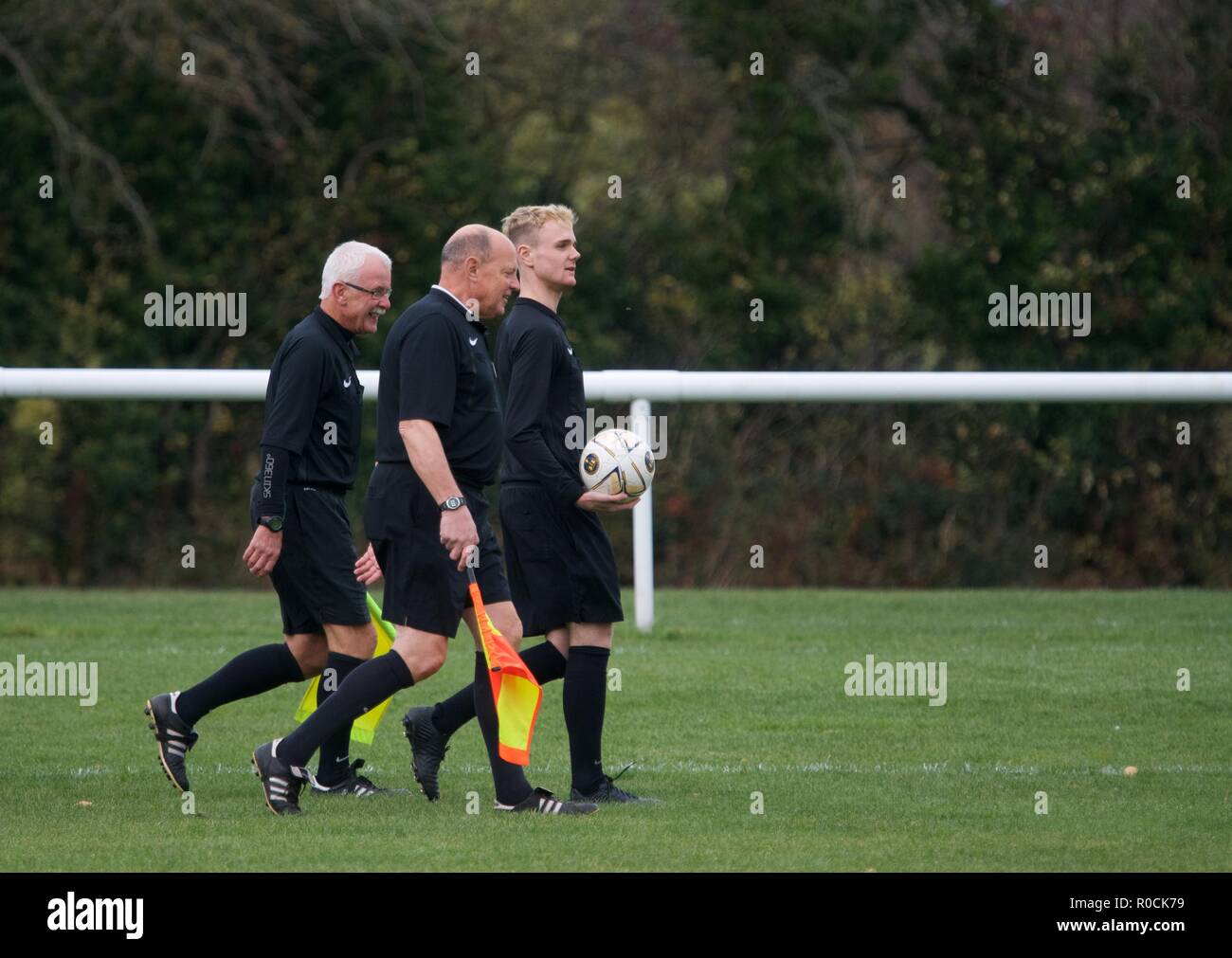 The referee and his assistants walk to the centre circle before the ...
