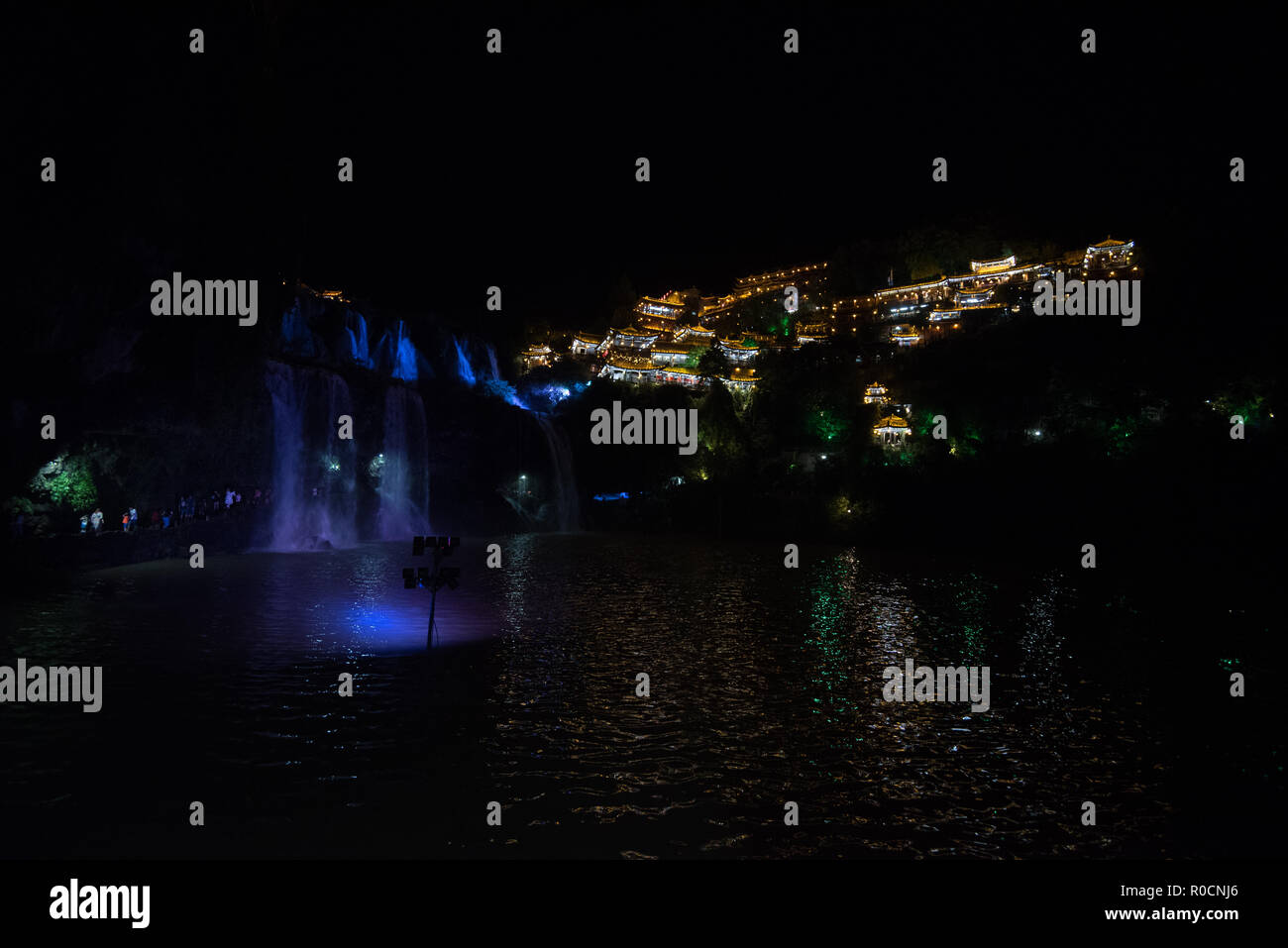 The Wangcun Waterfall at Furong Ancient Town illuminated at night Stock ...