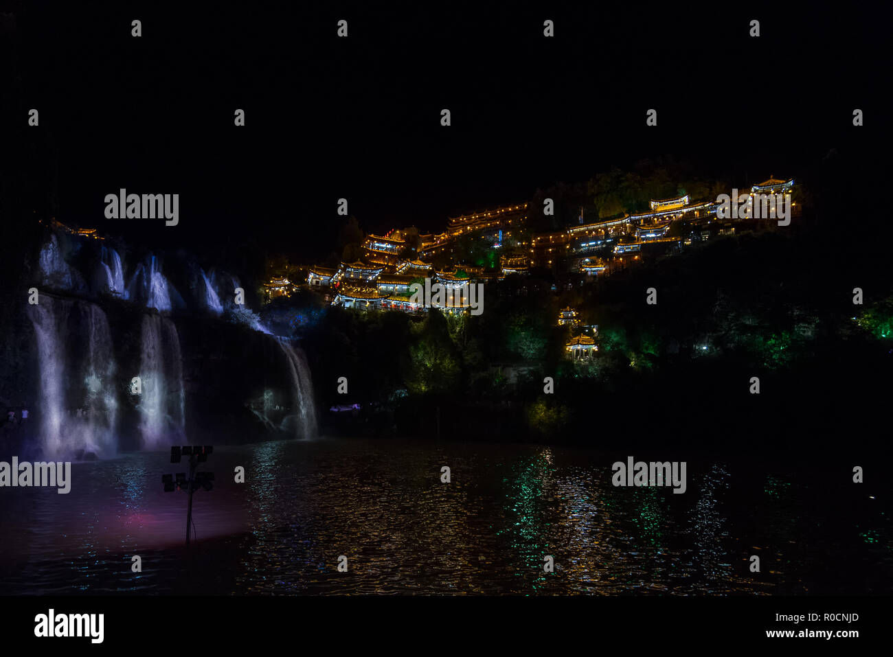 The Wangcun Waterfall at Furong Ancient Town illuminated at night Stock ...