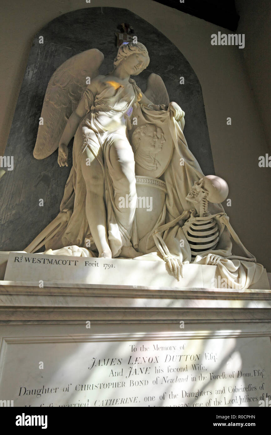 life-sized angel leans on a medallion with profiles of the deceased ...