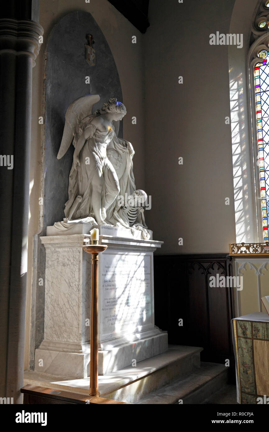 life-sized angel leans on a medallion with profiles of the deceased ...