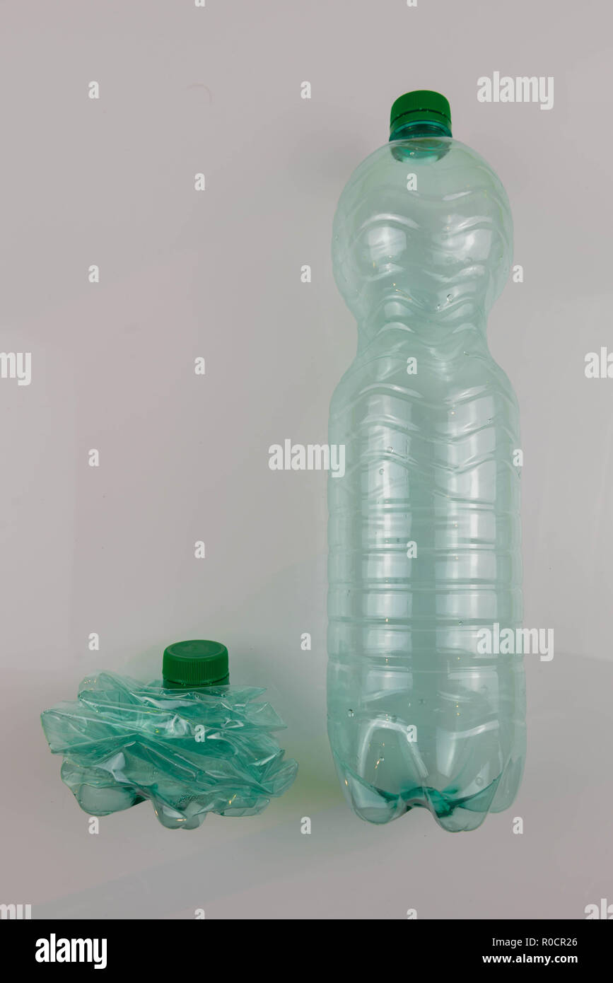 Crushed and uncrushed PET plastic bottle on a white isolated background ...