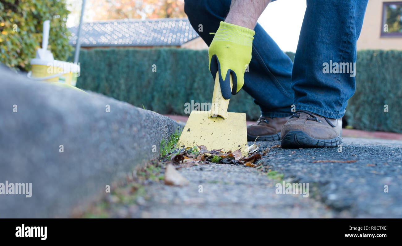 Man is cleaning the street gutter Stock Photo - Alamy