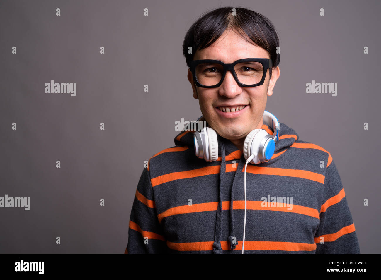 Young Asian nerd man wearing hoodie and headphones against gray Stock Photo - Alamy