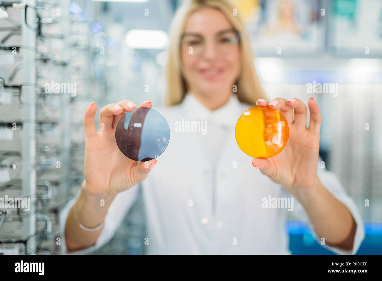 Female optician shows lenses of different colors, showcase with ...
