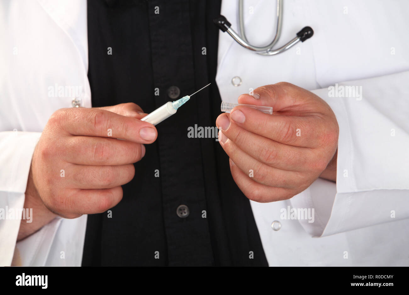 Handsome doctor wearing his uniform, holding injection by his both ...