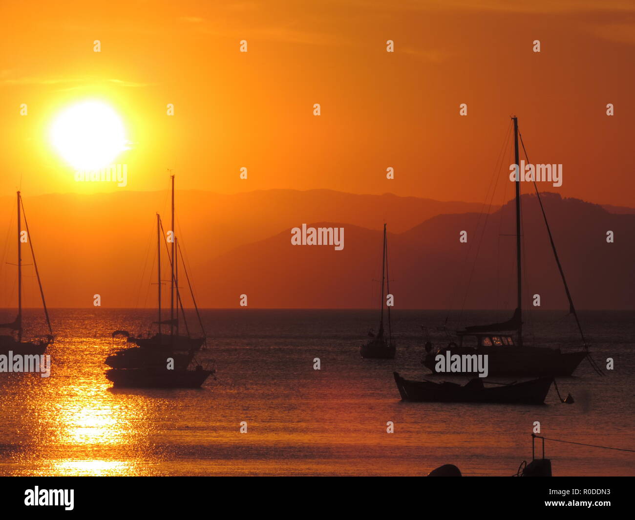 boats over sunset in the beach Stock Photo - Alamy