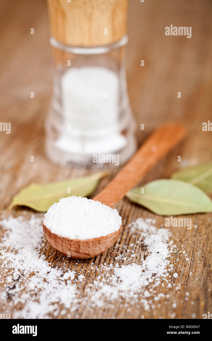 salt in spoon and shaker, bay leaves on rustic wooden table Stock Photo ...