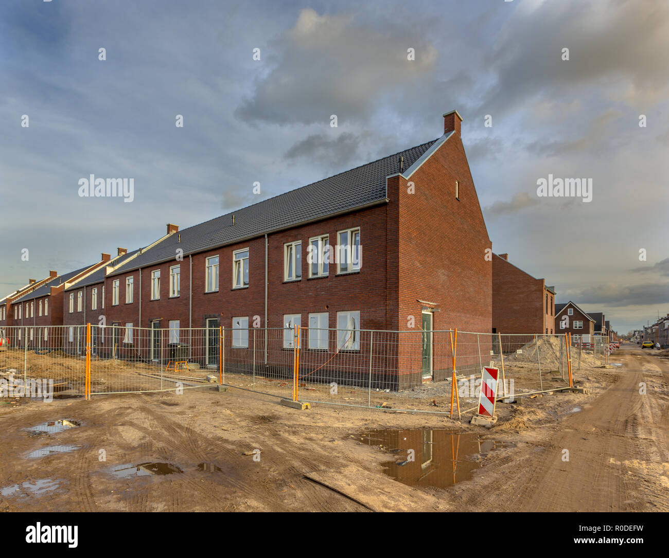 New completed young family houses on a builing site with unpaved roads ...