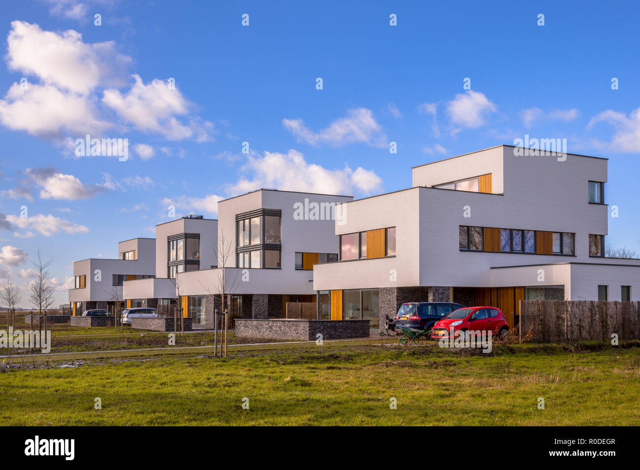 Modern geometric family houses along a green modern residential ...