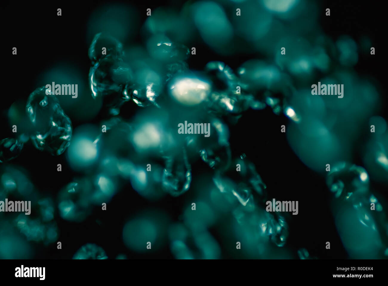 Blurred drops of water flying macro shot in emerald green color Stock ...