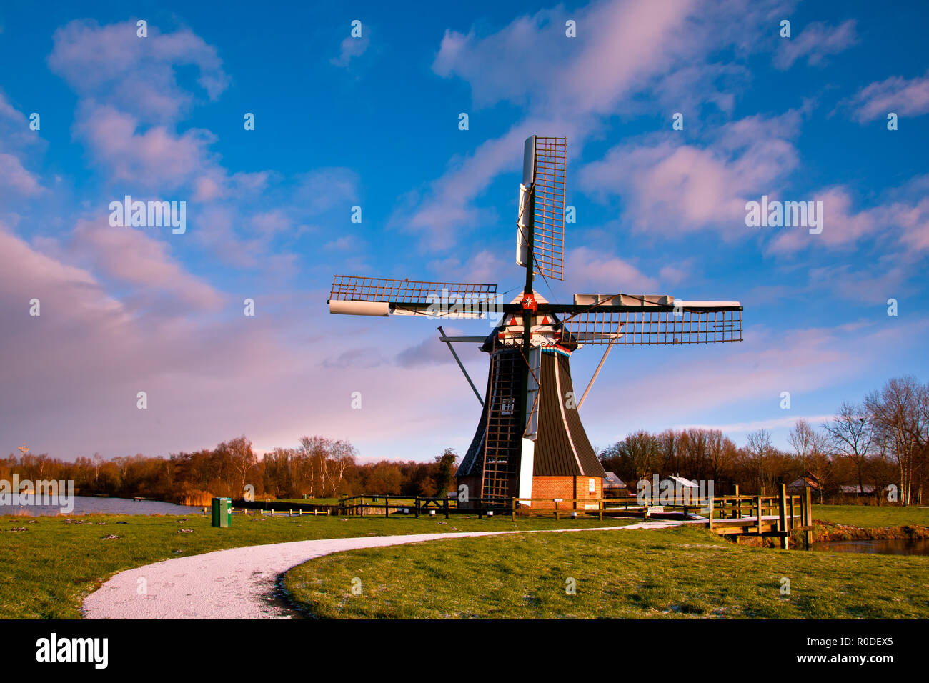 Dutch Windmill on the Waterfront of a Lake with Spectacular Clouds ...