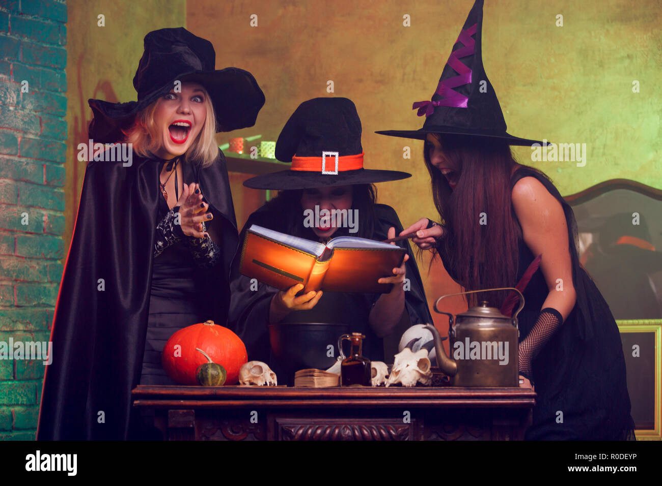 Picture of three young witches with book of predictions in hands Stock ...