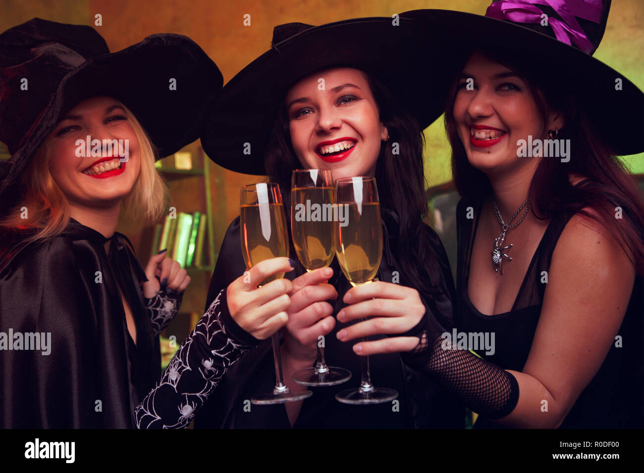 Picture of three young witches with glass of champagne Stock Photo - Alamy