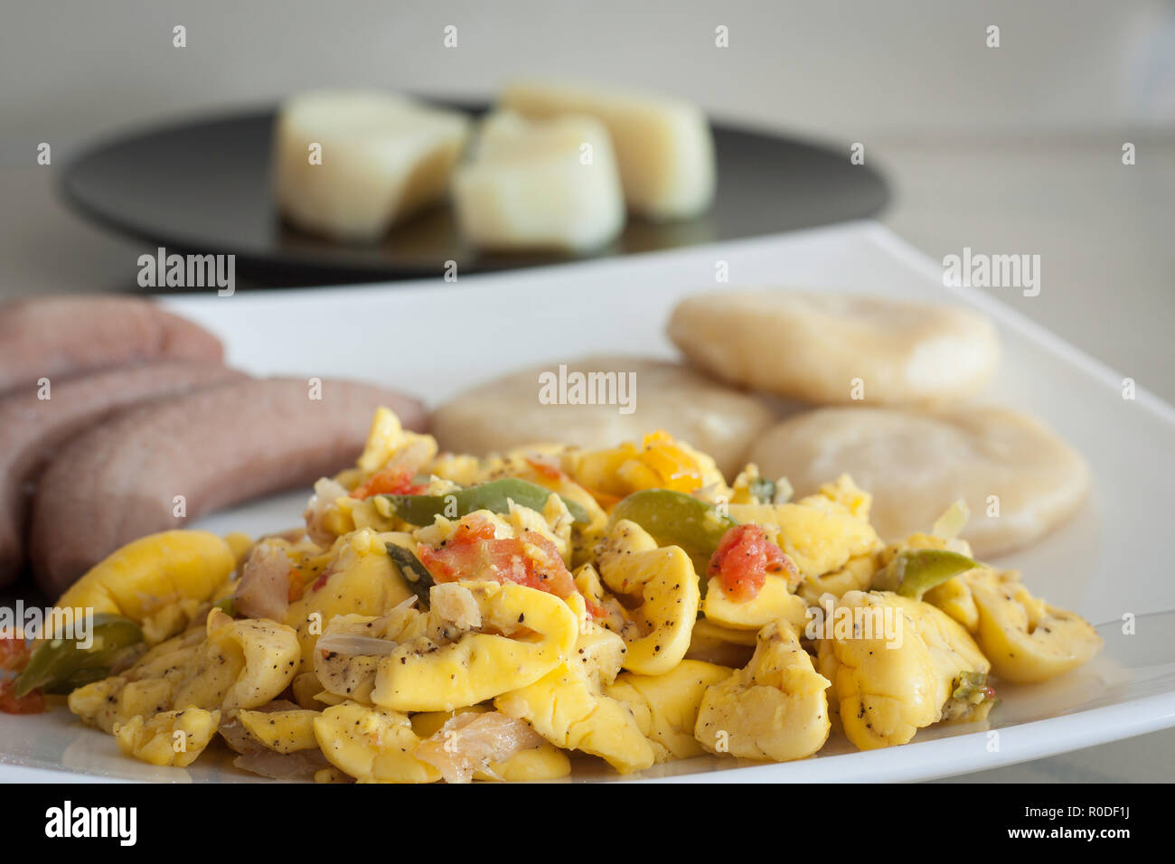 Ackee and Salt Fish with boiled bananas and dumplings served on a white ...