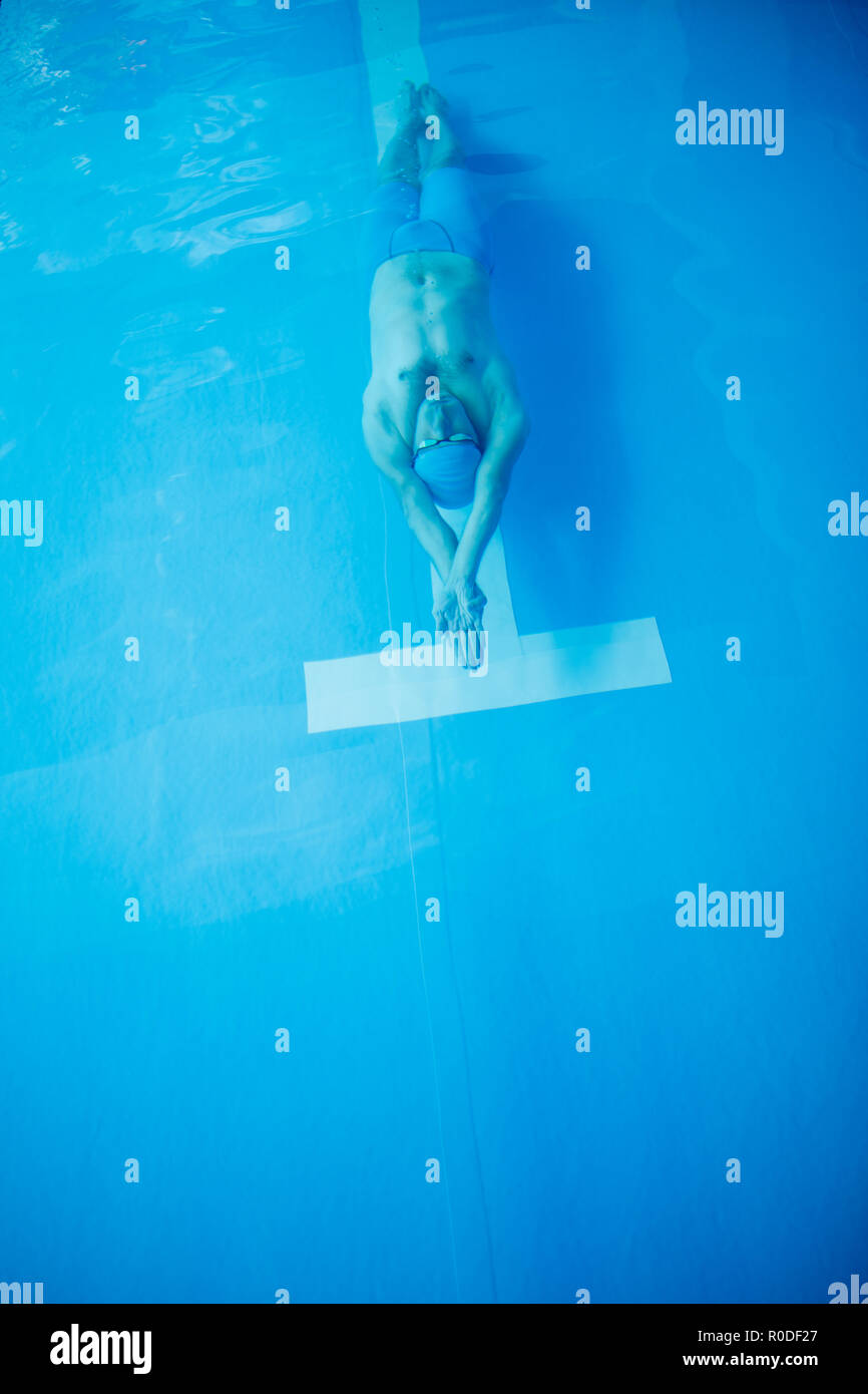 Photo on top of athlete man swimming on back of indoor pool Stock Photo ...
