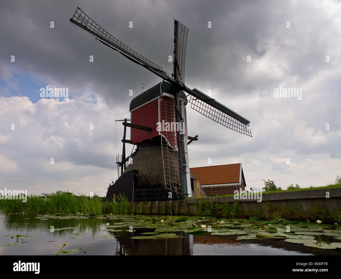 Historic dutch vintage windmill under brooding sky Stock Photo - Alamy