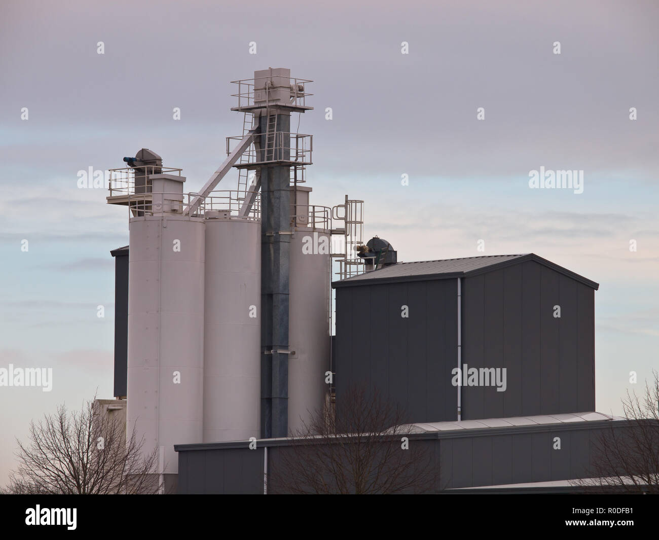 Grey factory building with silos Stock Photo - Alamy