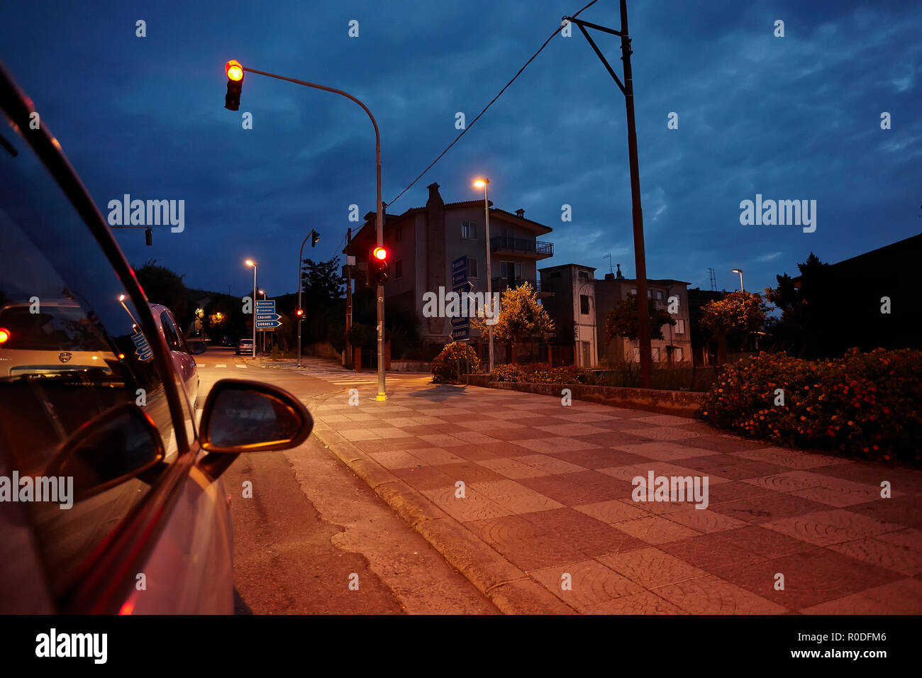 Night view from a car window of a red light intersection of a small ...