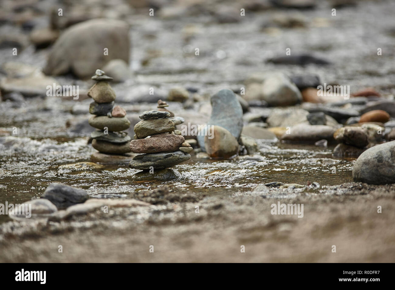 Several stacks of rocks interrupt the flow of water in the stream Stock ...