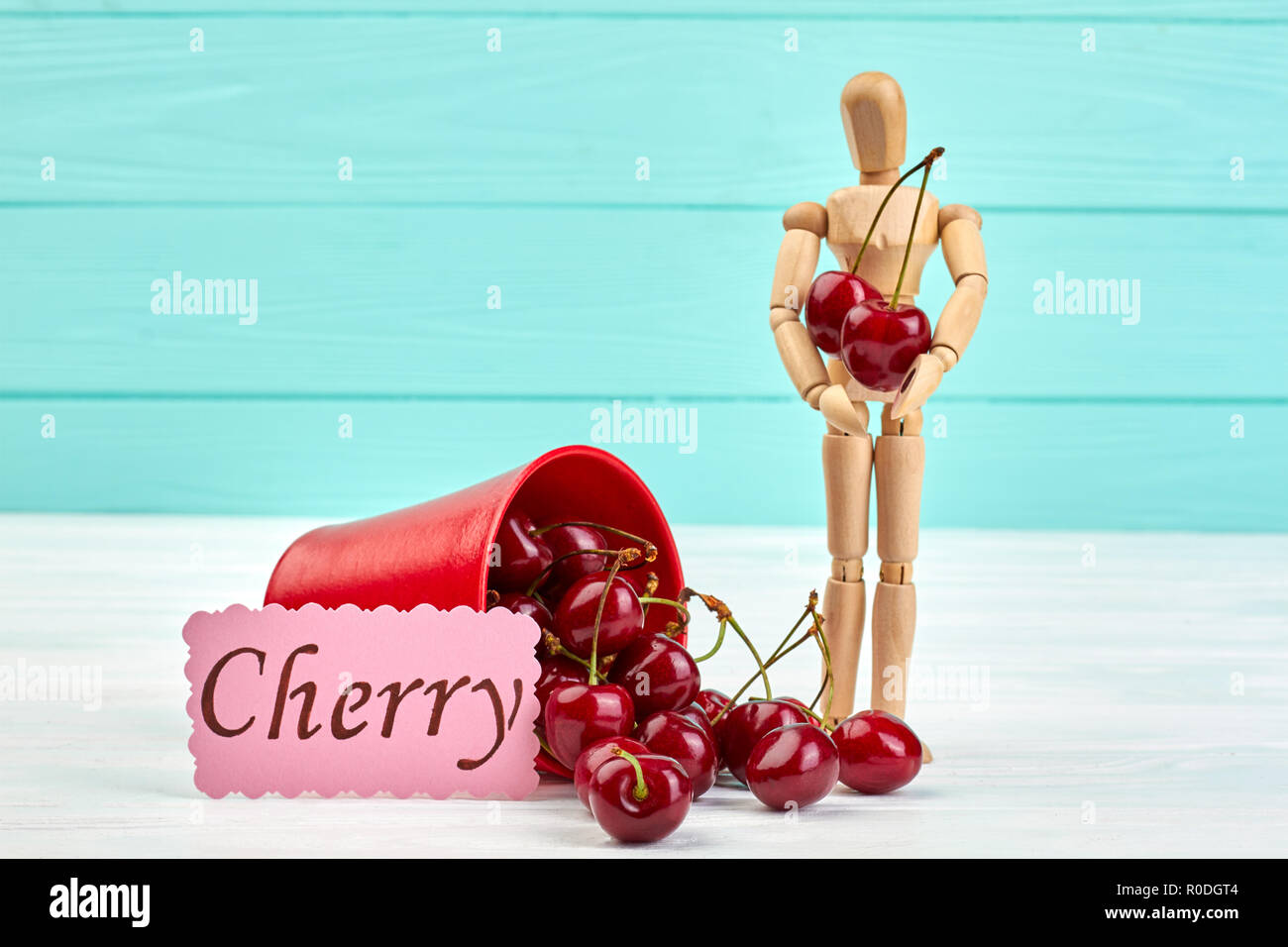 Wooden puppet and red sweet cherries Stock Photo - Alamy
