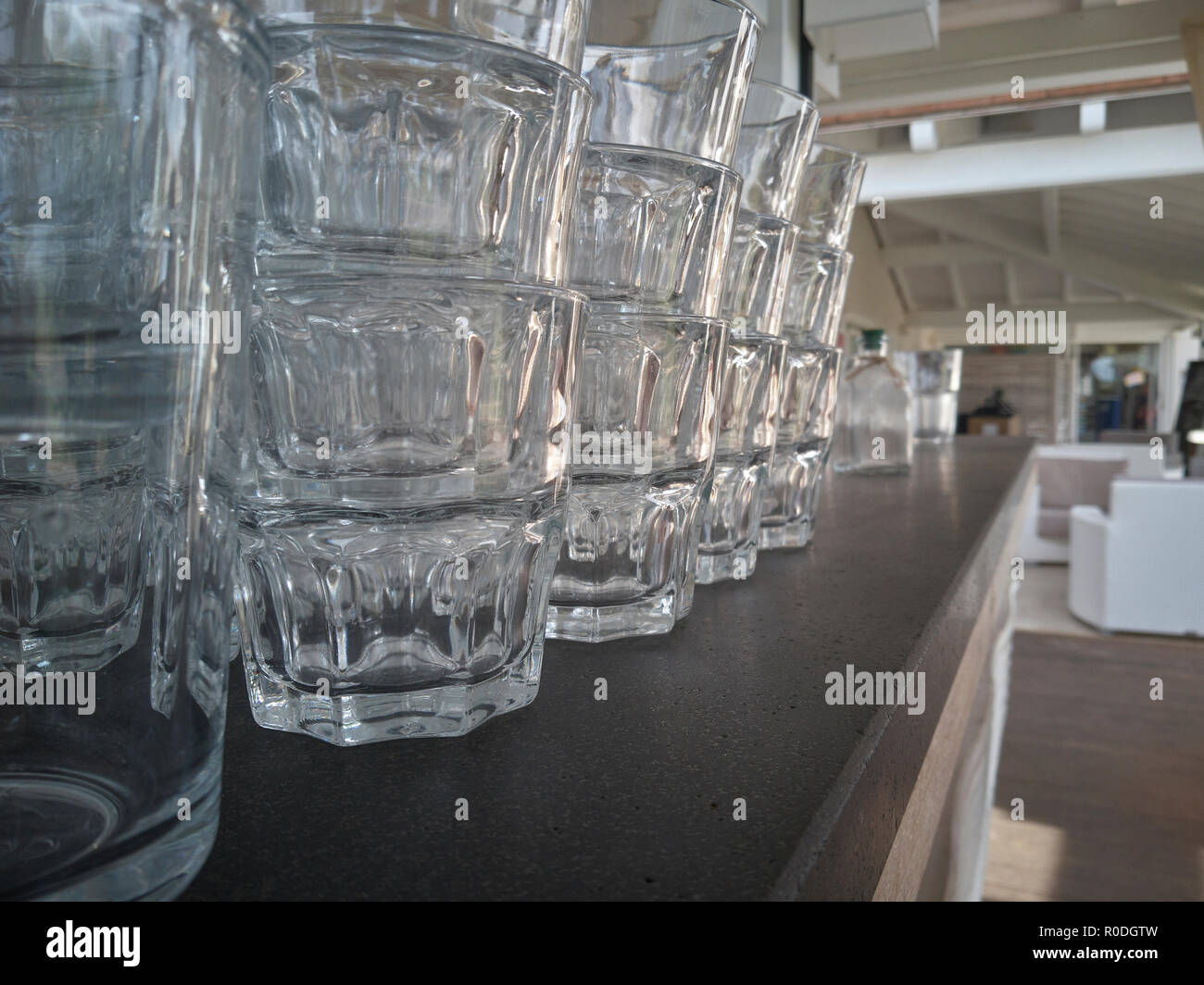 Rows of glasses stacked on top of each other above a bar counter Stock ...