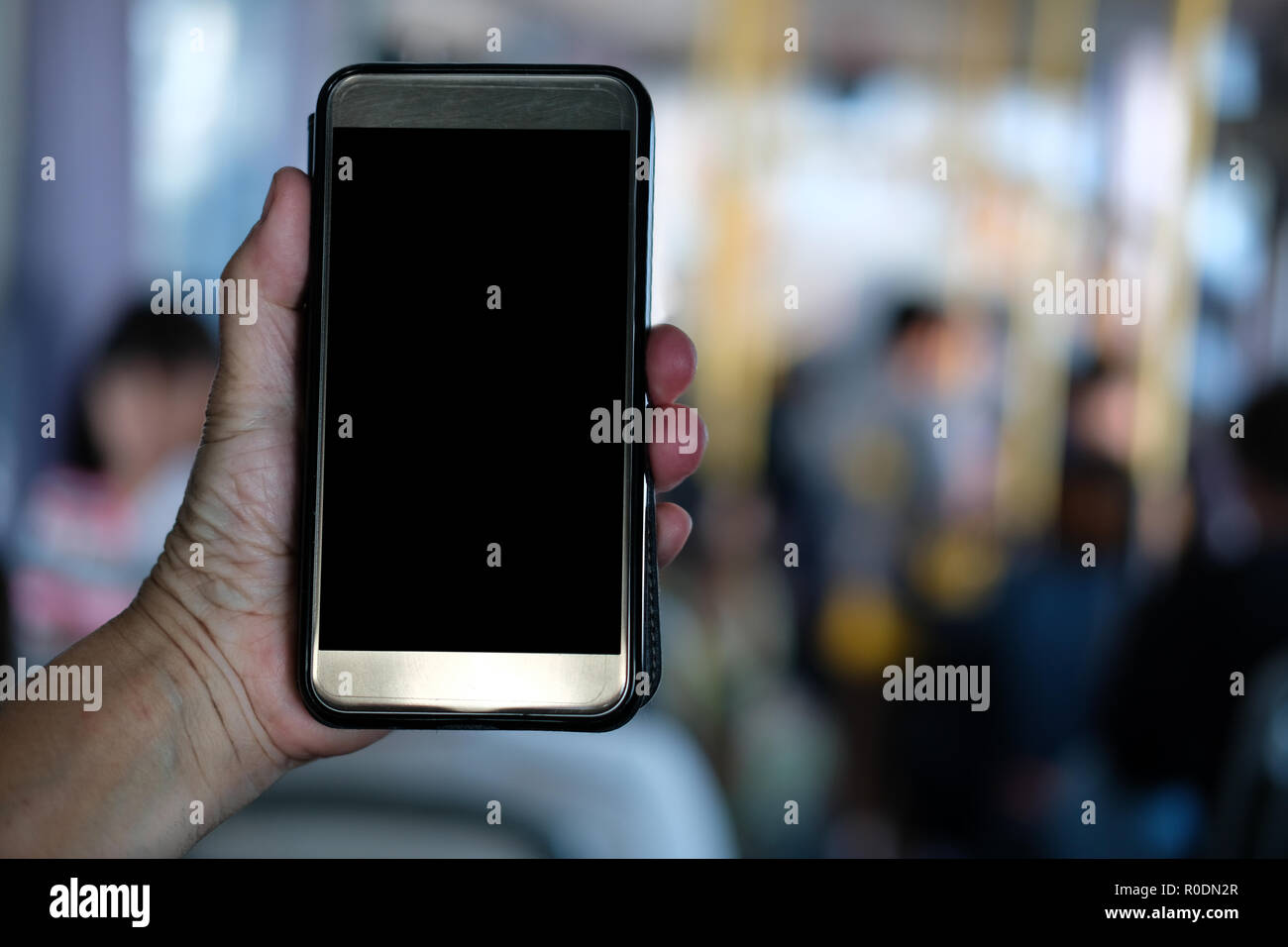 hand holding smartphone while riding on commuter bus. people travelling ...