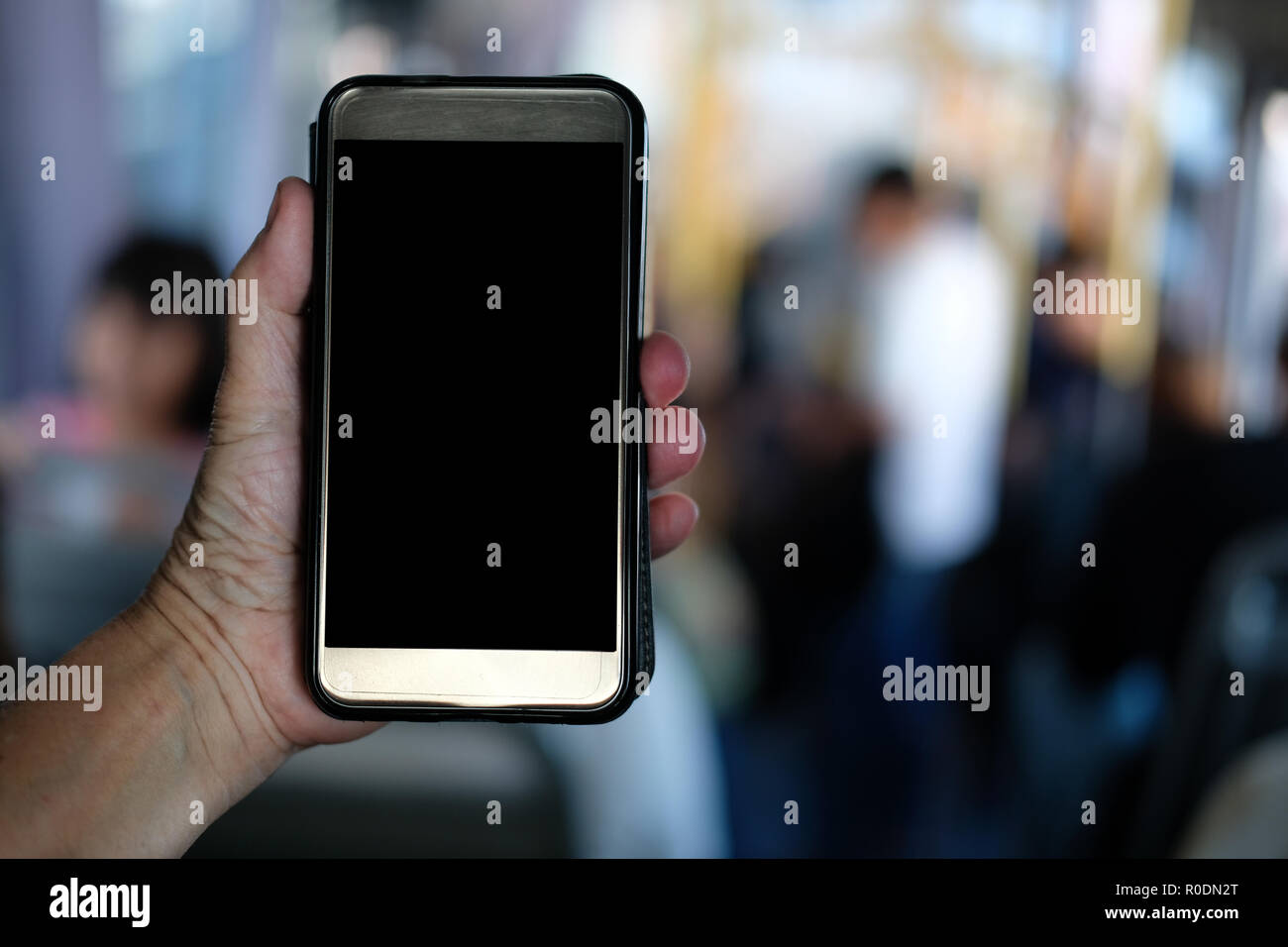 hand holding smartphone while riding on commuter bus. people travelling ...