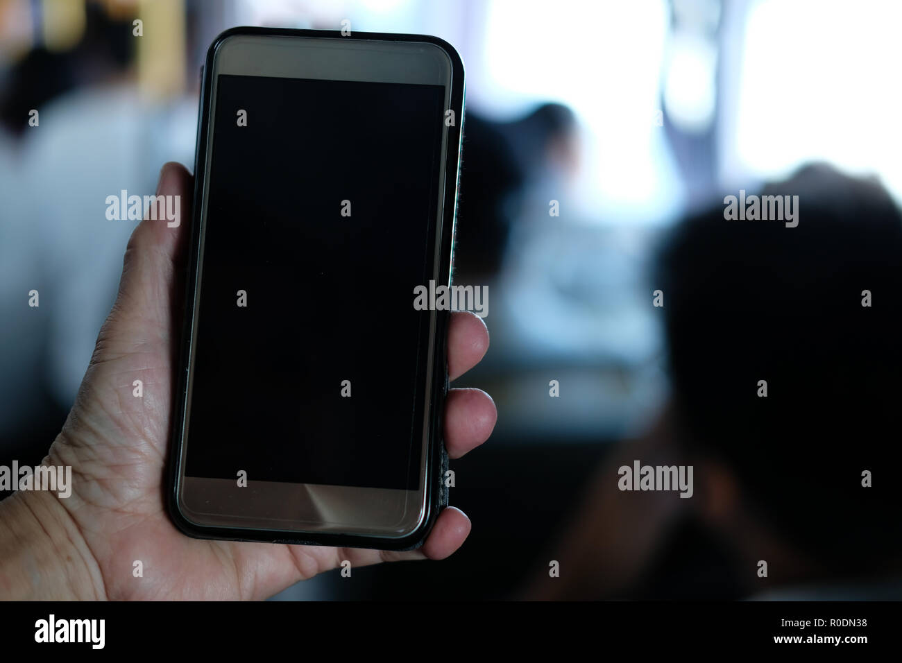hand holding smartphone while riding on commuter bus. people travelling ...