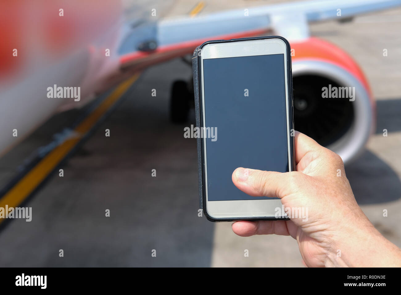 hand holding mobile smart phone with airplane wing background Stock ...