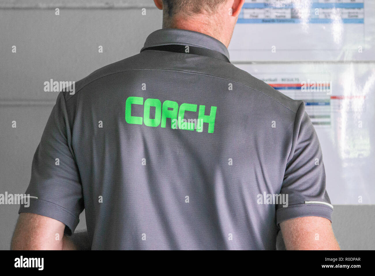 Back view of male sport coach with word COACH written on back of his ...