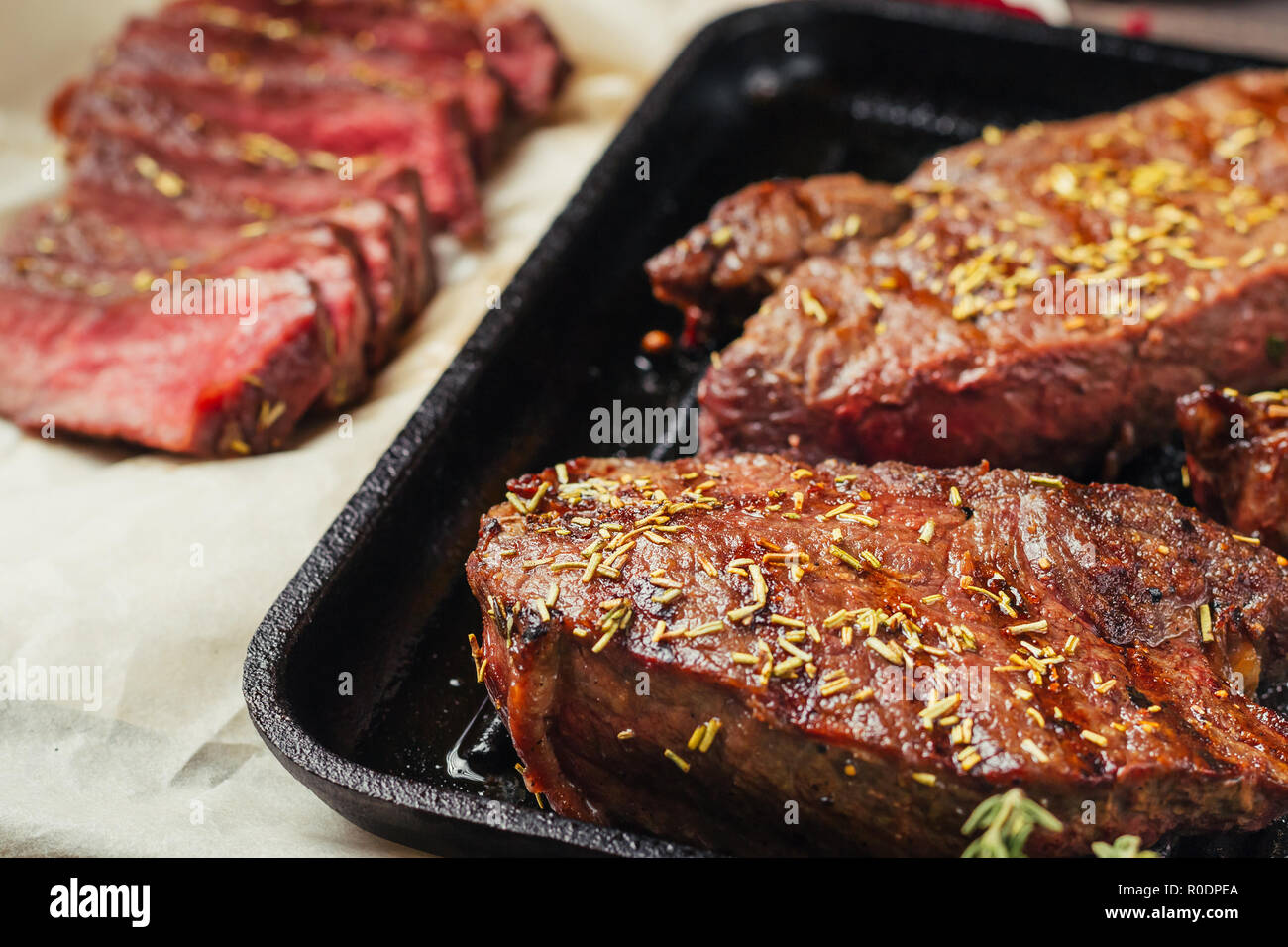 Grilled beef steak on frying pan, top view. Fried chunks of meat close ...