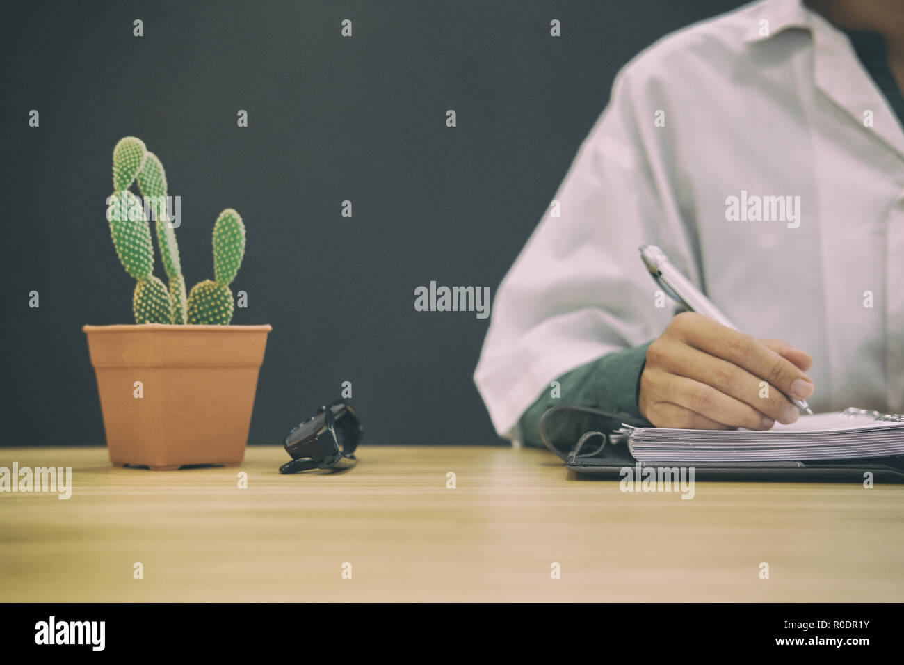 doctor working with cactus plant & eyeglasses on desk at clinic ...
