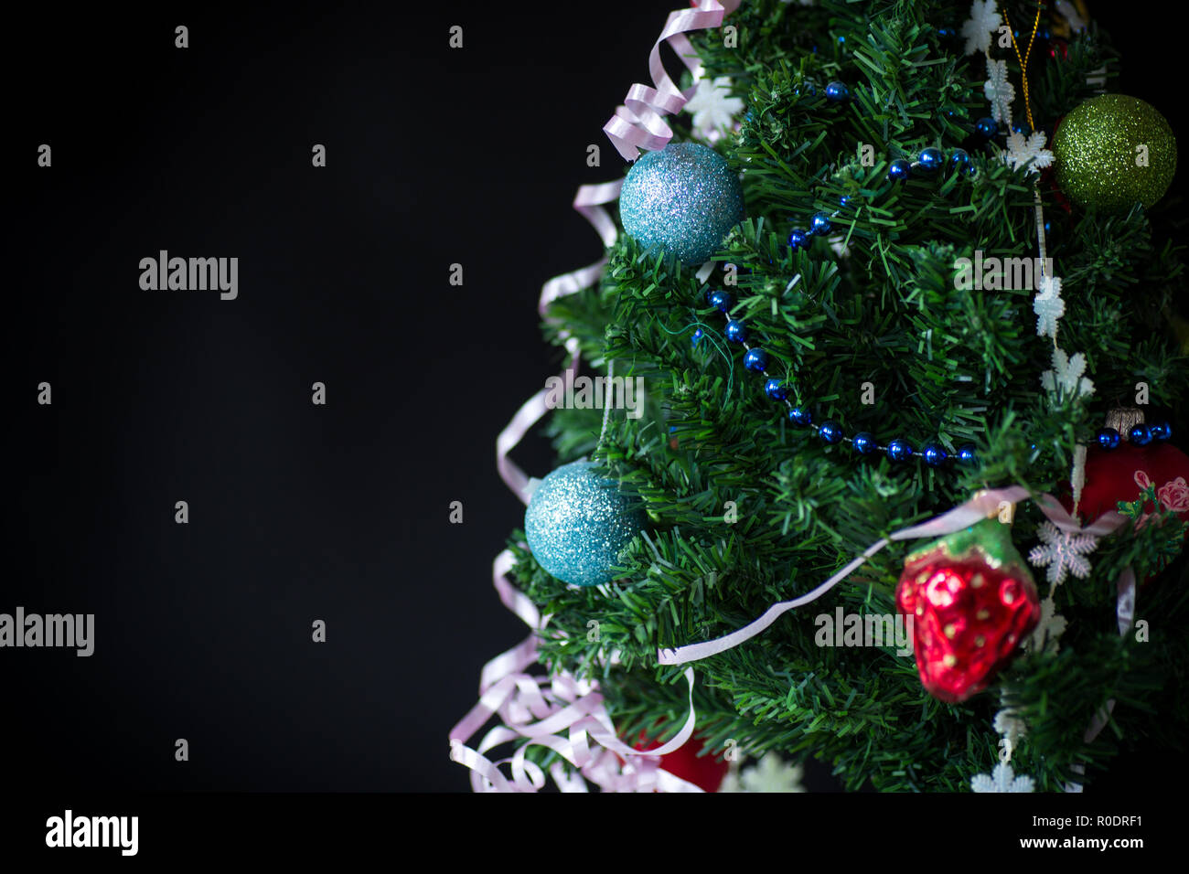 Christmas tree with decorations on a black background Stock Photo - Alamy