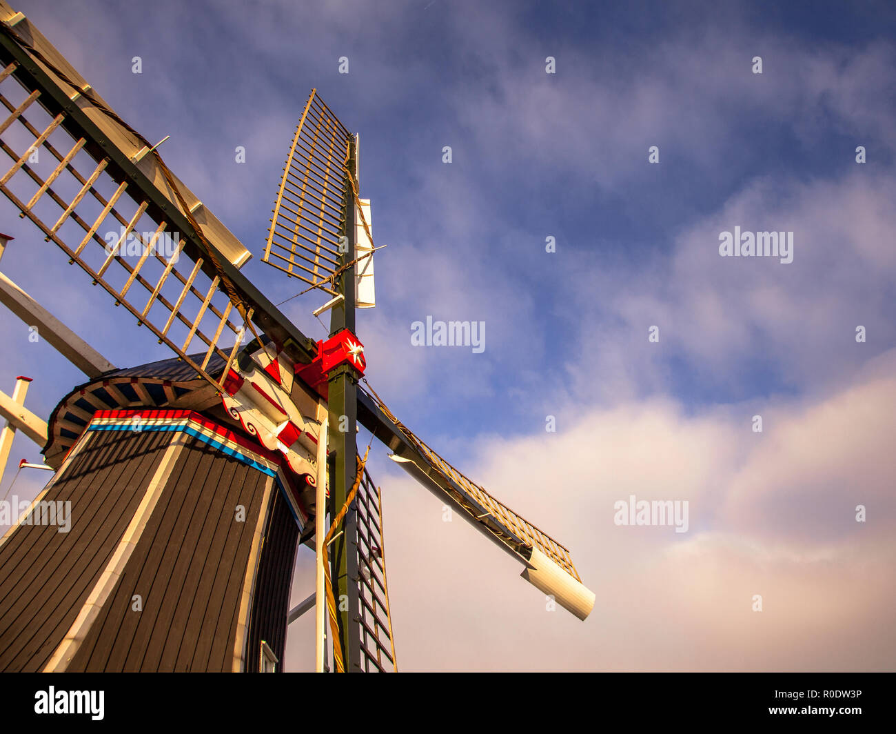 Dutch Windmill during sunset against blue sky with fluffy Clouds Stock ...