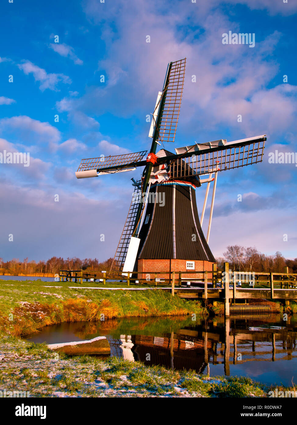 Dutch Windmill on the Waterfront of a Lake with Spectacular Clouds ...