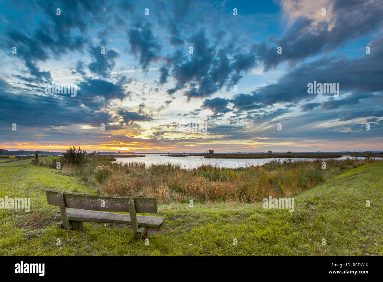 Wooden Bench overlooking a Beautiful Cloudscape above a Lake during ...