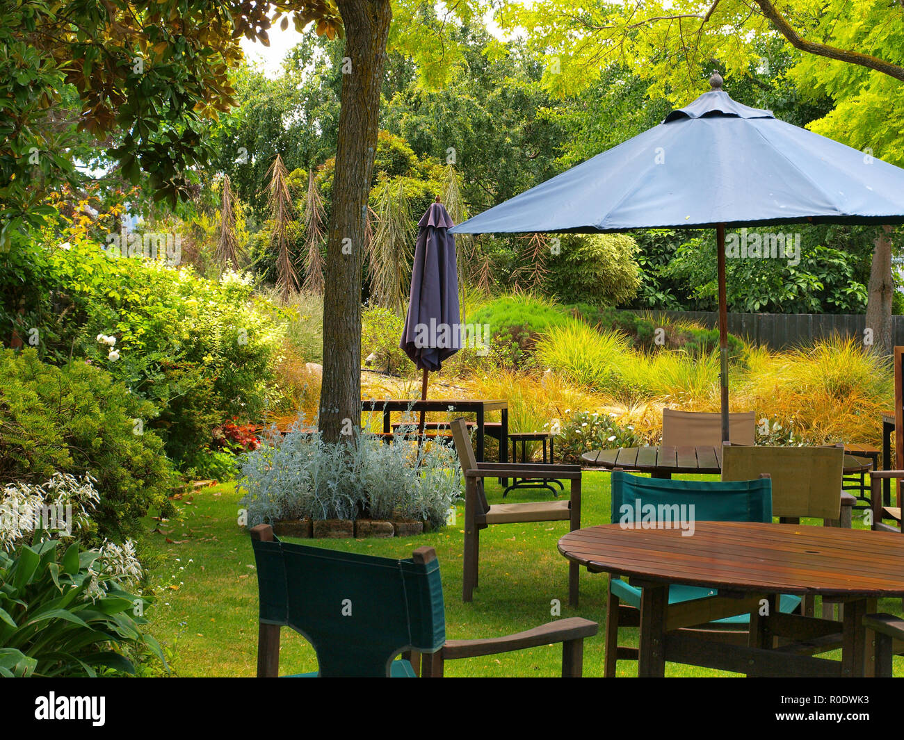 dining table in sunny garden patio with sunshade Stock Photo - Alamy