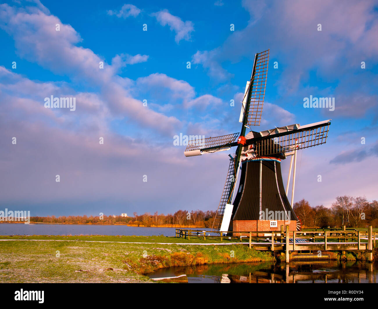 Dutch Windmill on the Waterfront of a Lake with Spectacular Clouds ...