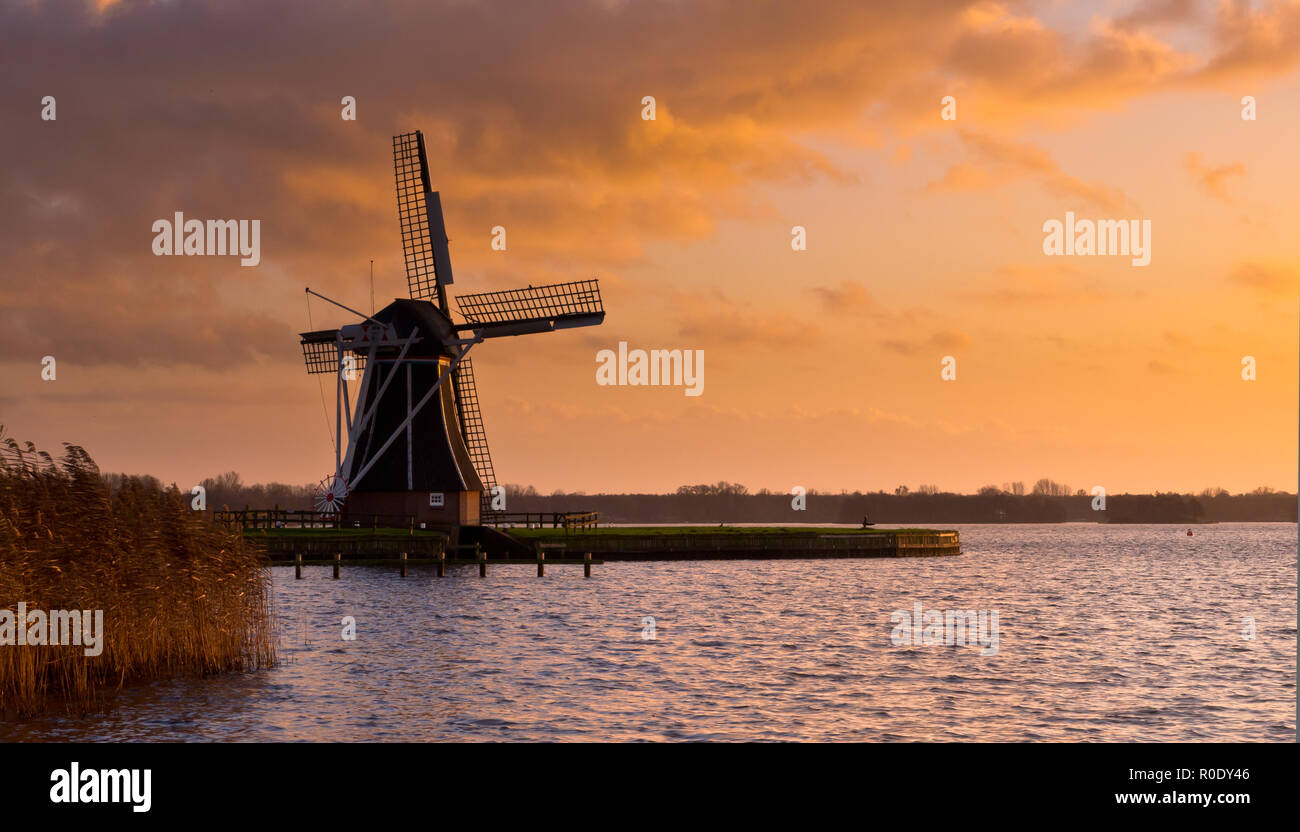 Dutch Windmill on the Waterfront of a Lake with Spectacular Clouds ...